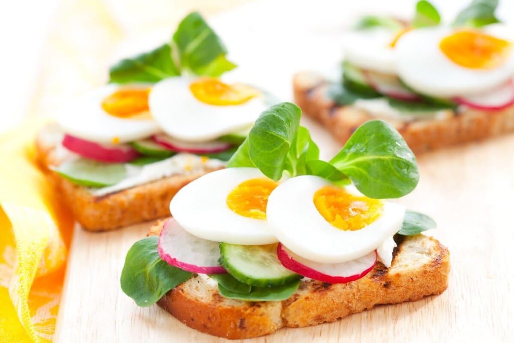 Toast mit Ei, Radieschen und Gurken zum Frühstück